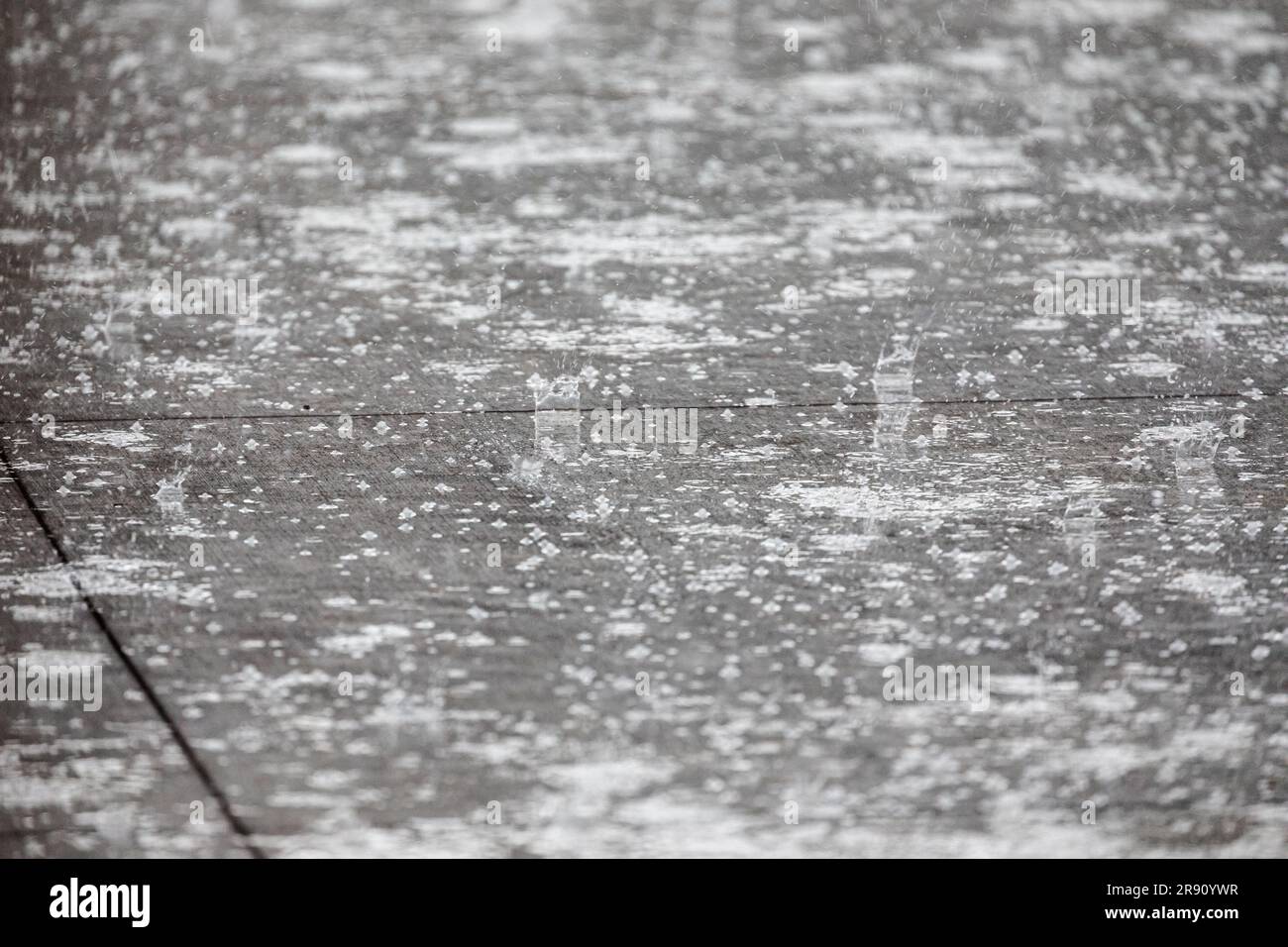 Rain splattering on pavement with small pieces of hail Stock Photo - Alamy