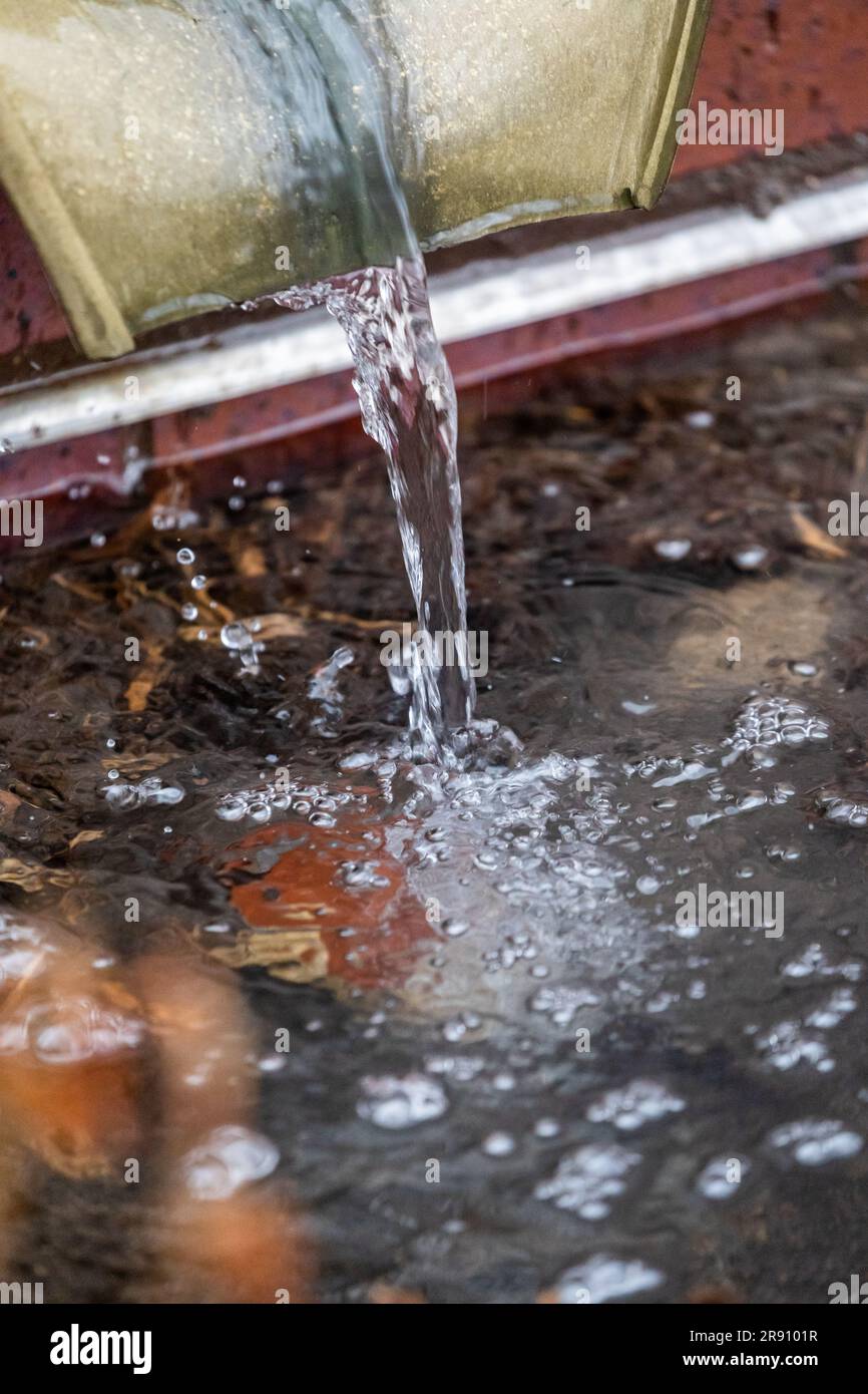 Water exiting a drain spout Stock Photo - Alamy