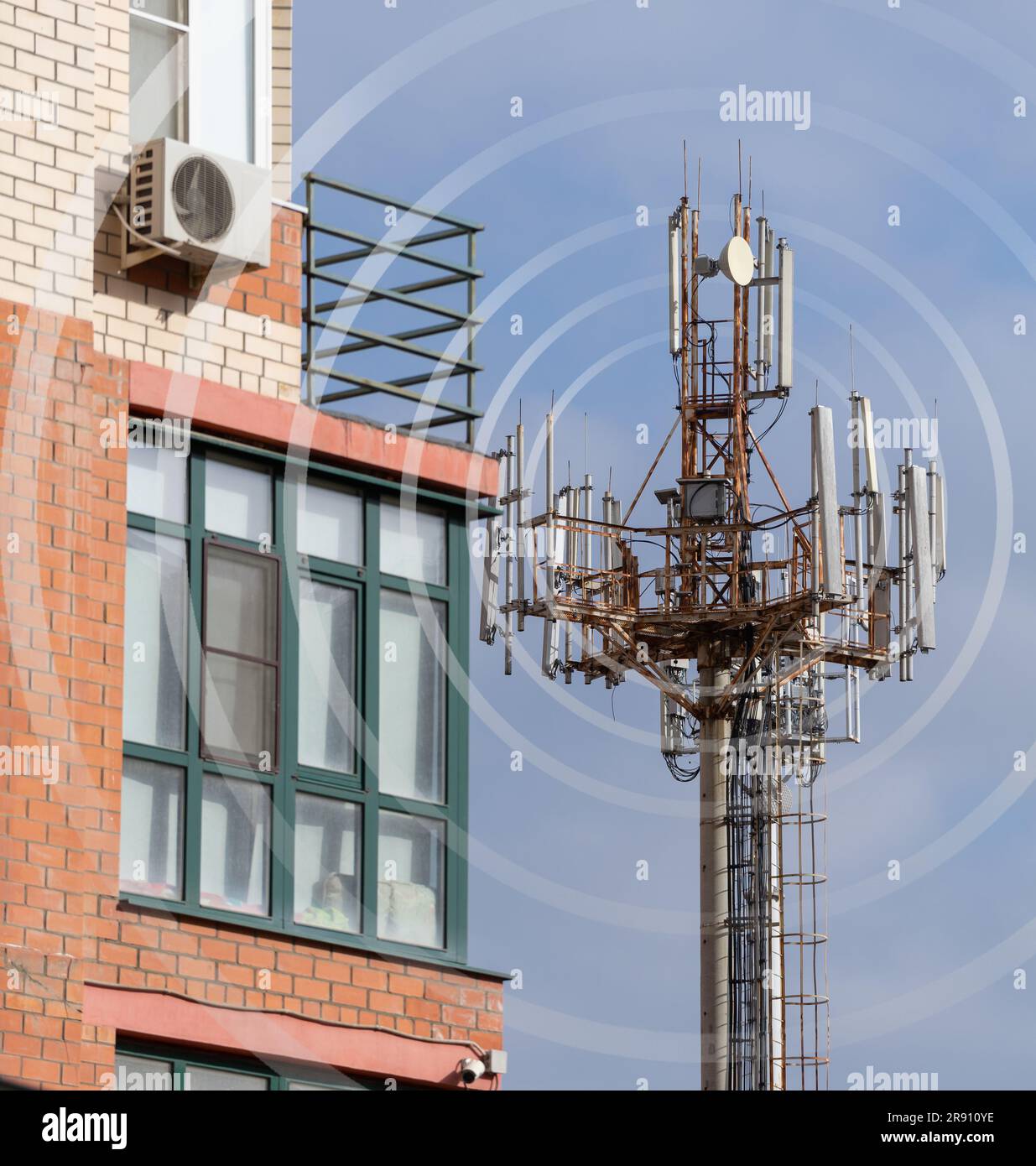 Telecommunication antenna on a tower near a residential multi-storey ...