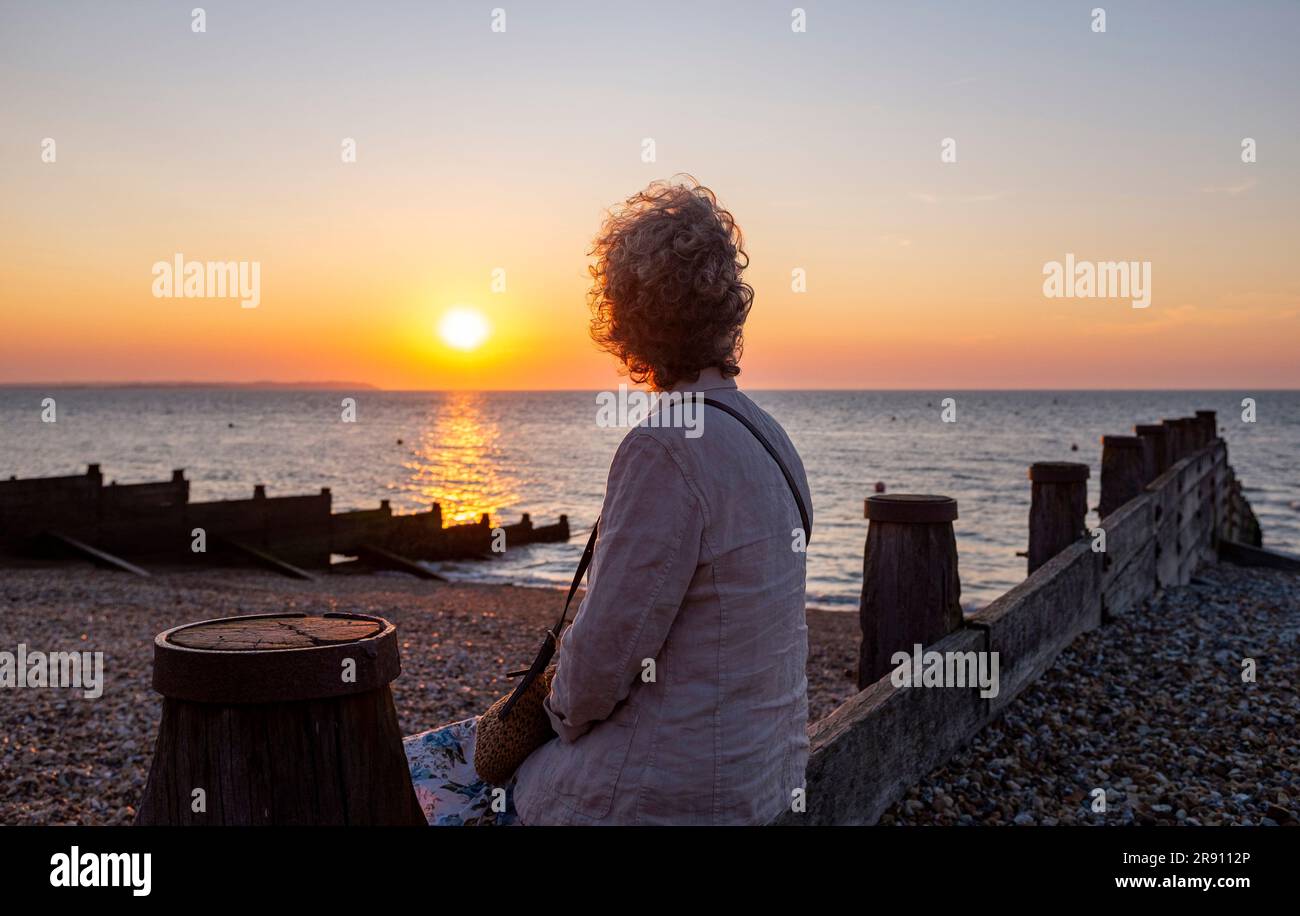 Whitstable North Kent , England UK - A woman enjoys the sunset over the ...