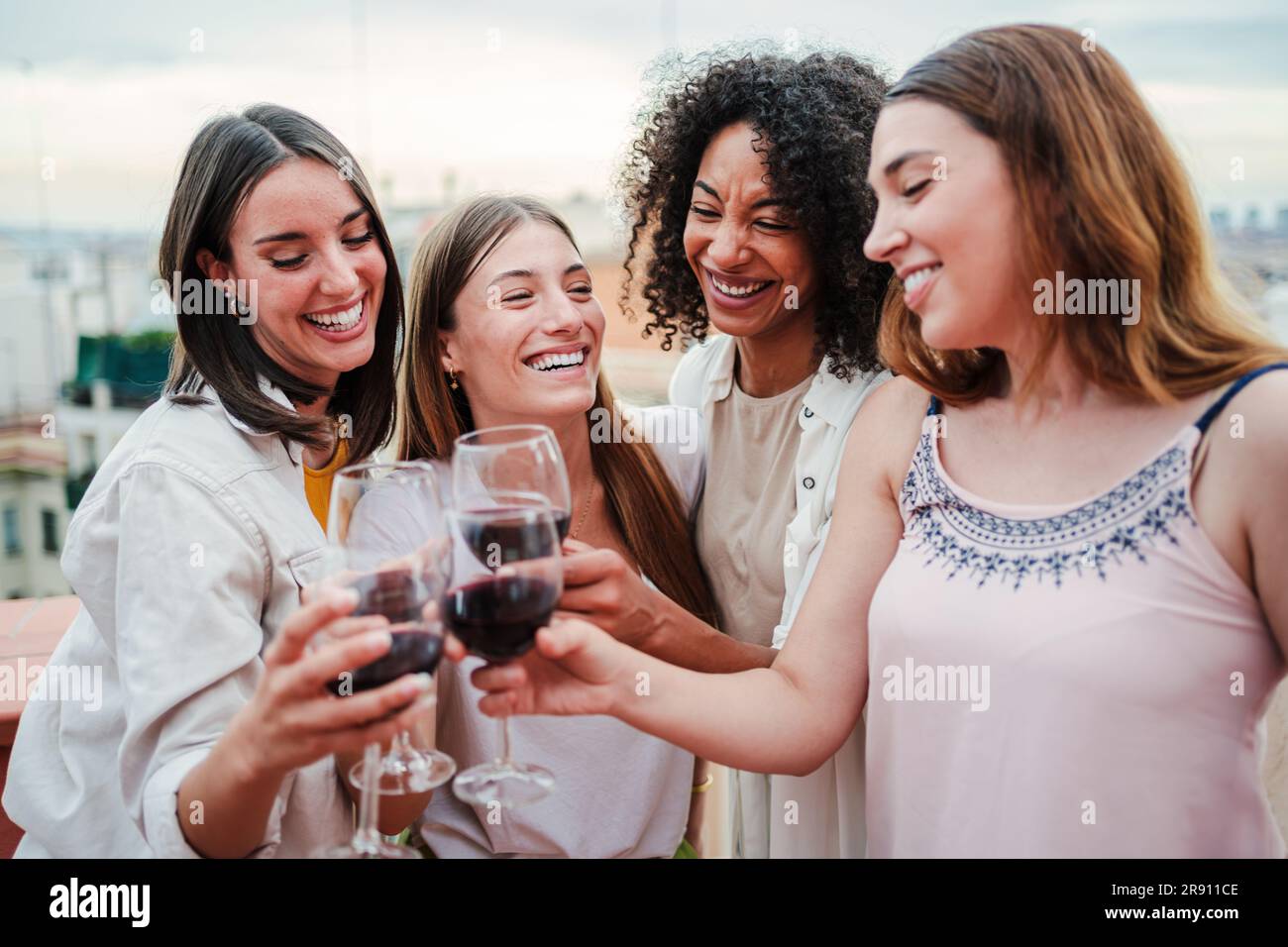 Group of happy young women friends having fun toasting wine glasses on ...