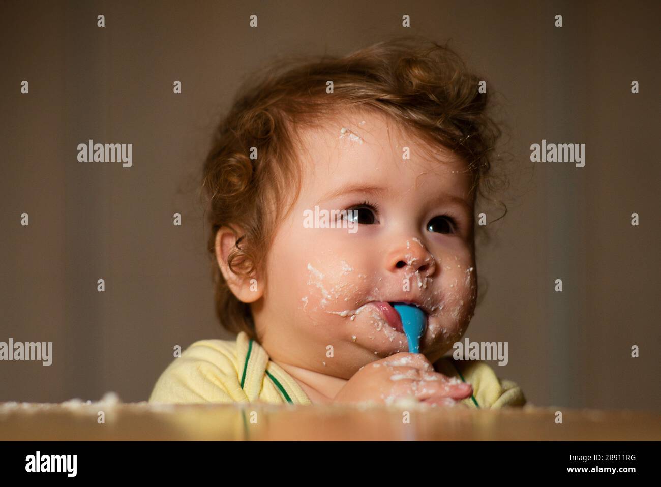 Kids baby eating with dirty face. Cheerful smiling child child eats ...