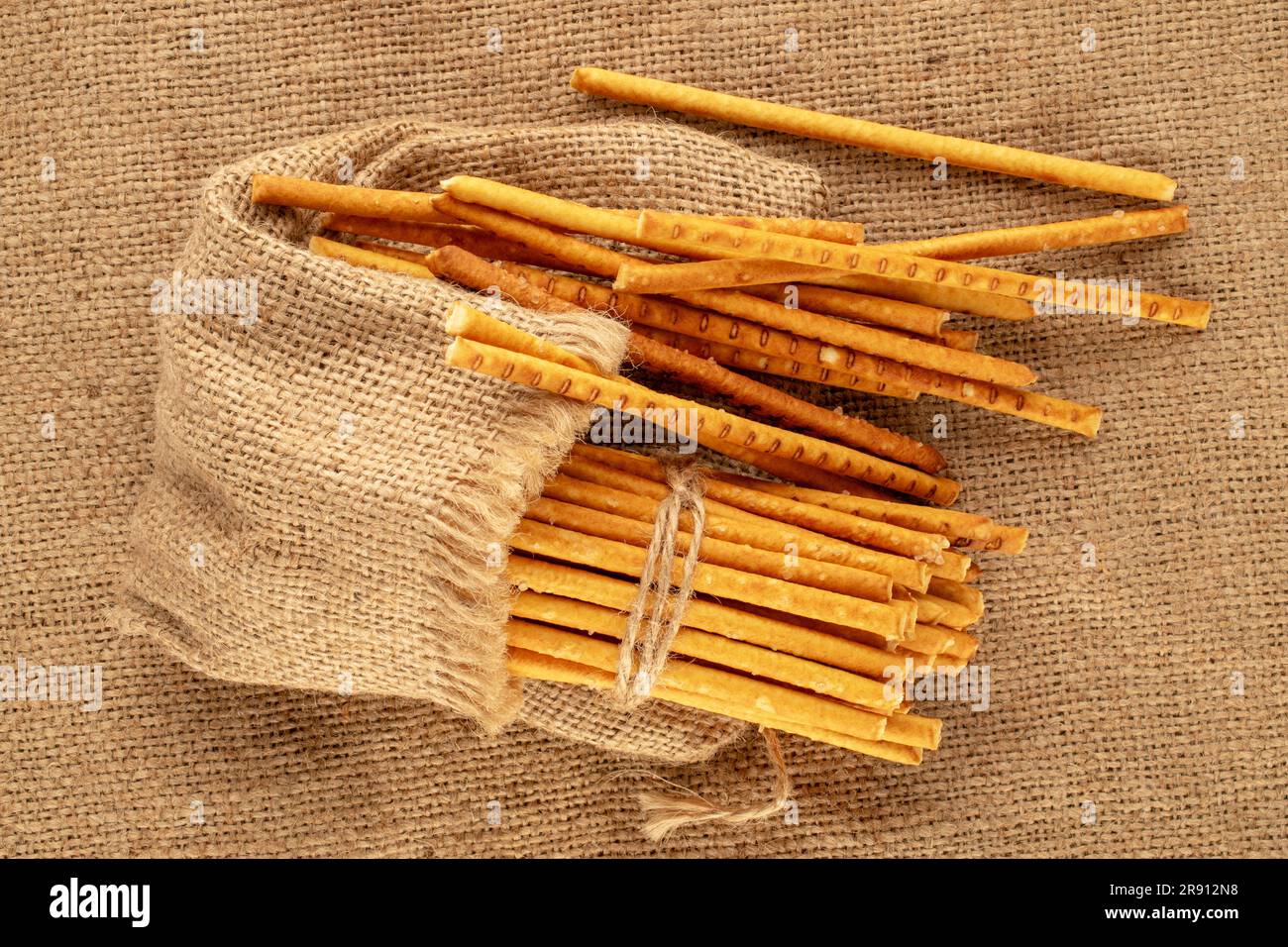 Straw is a bakery product. Several straws with jute bag on jute canvas ...