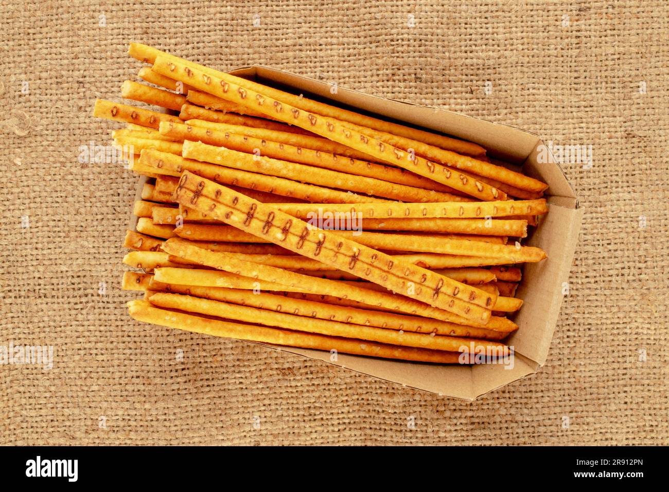 Straw is a bakery product. Several straws with a paper plate on a jute ...
