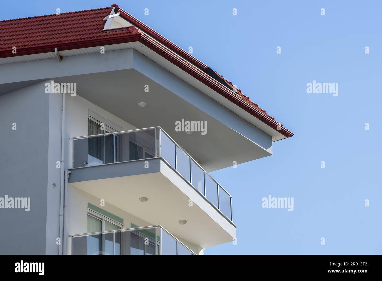 An open balcony located on the top floor of a residential building. The ...