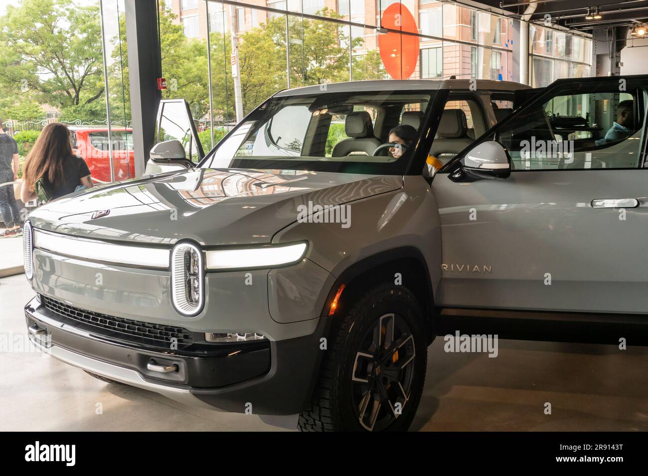 Automobile enthusiasts attend the grand opening of a Rivian Spaces ...