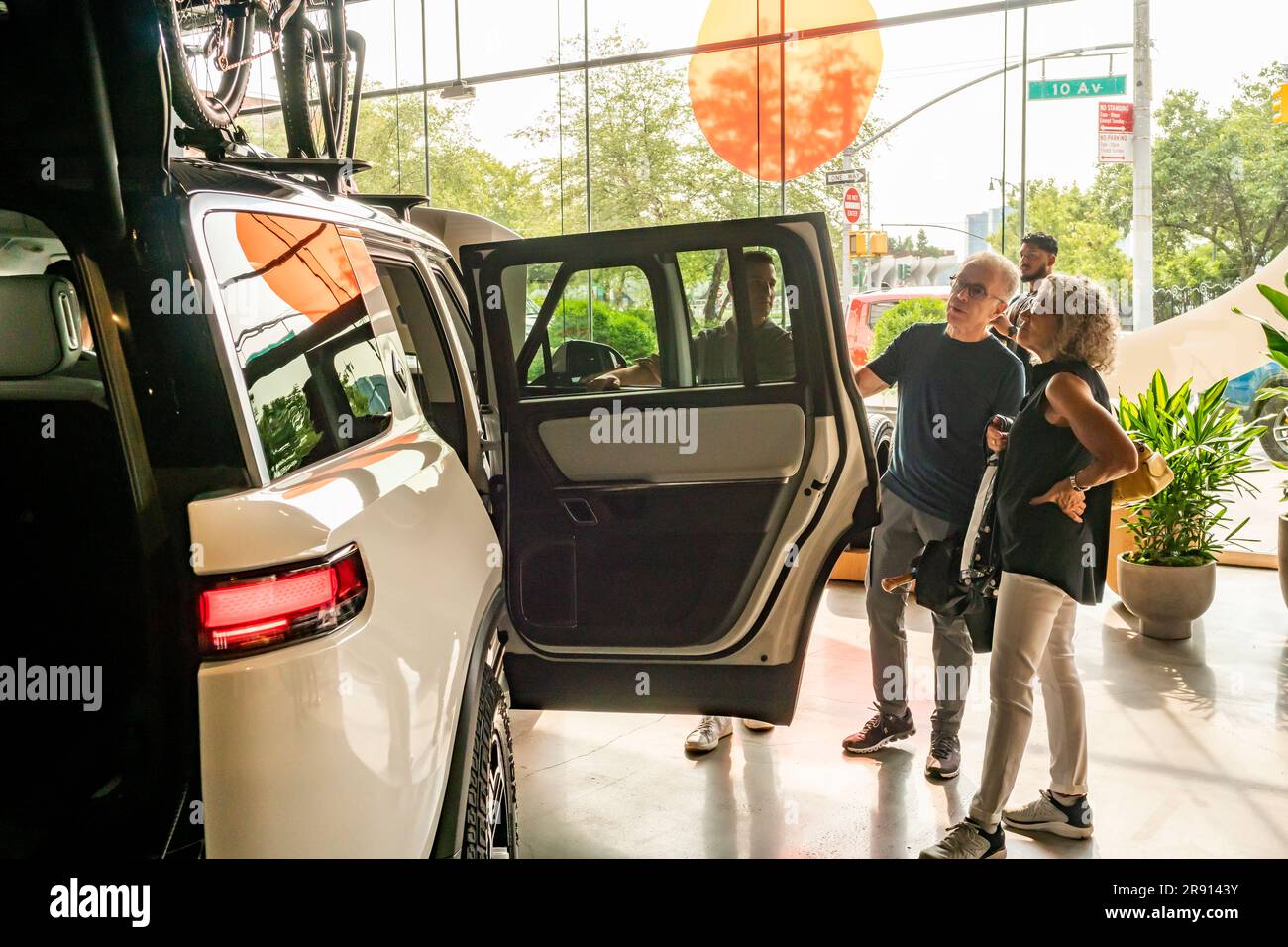 Automobile enthusiasts attend the grand opening of a Rivian Spaces ...
