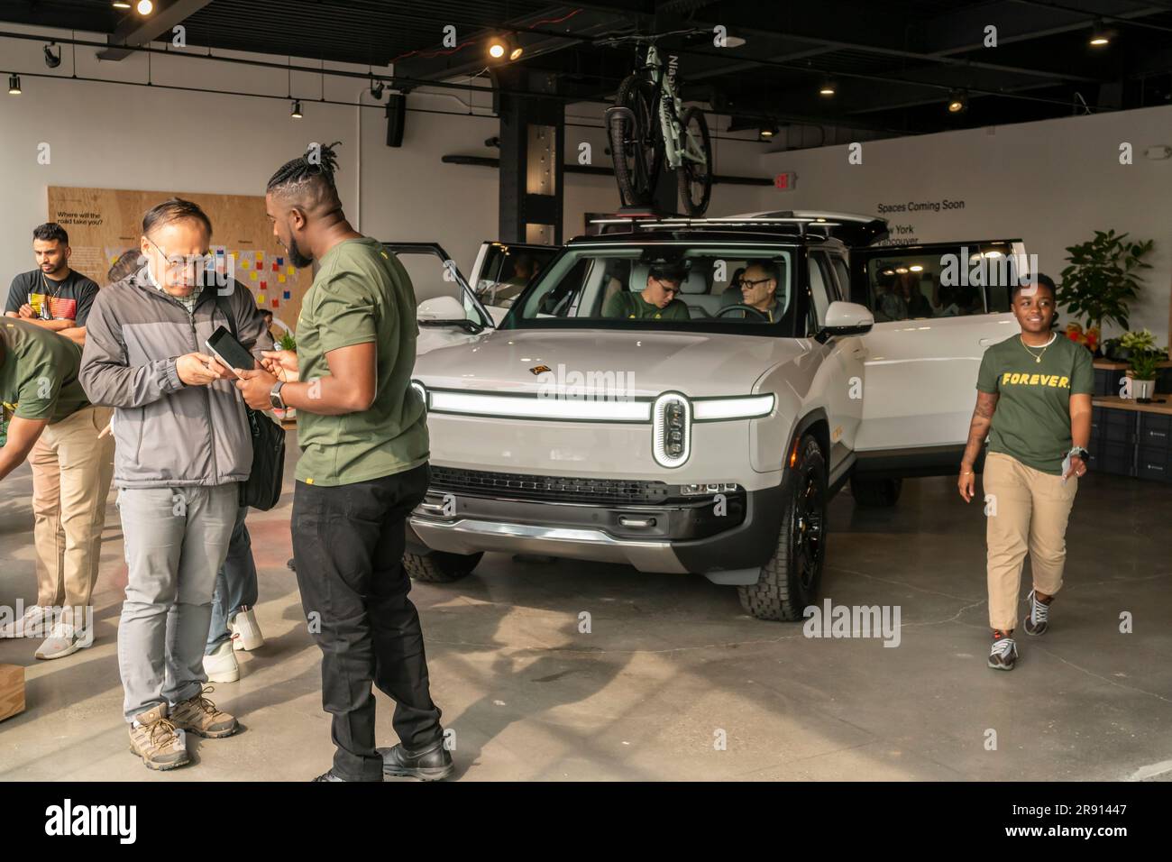Automobile enthusiasts attend the grand opening of a Rivian Spaces ...