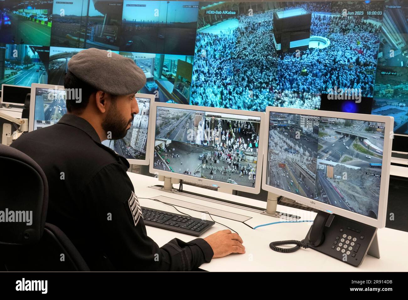 A Saudi police officer monitors screens displaying the Grand Mosque, at ...