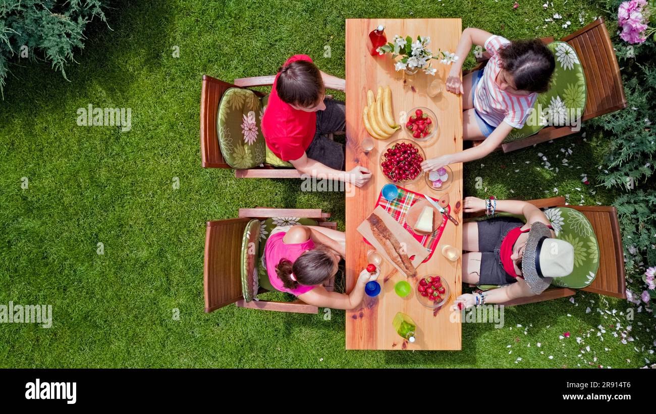 Family and friends eating together outdoors on summer garden party ...