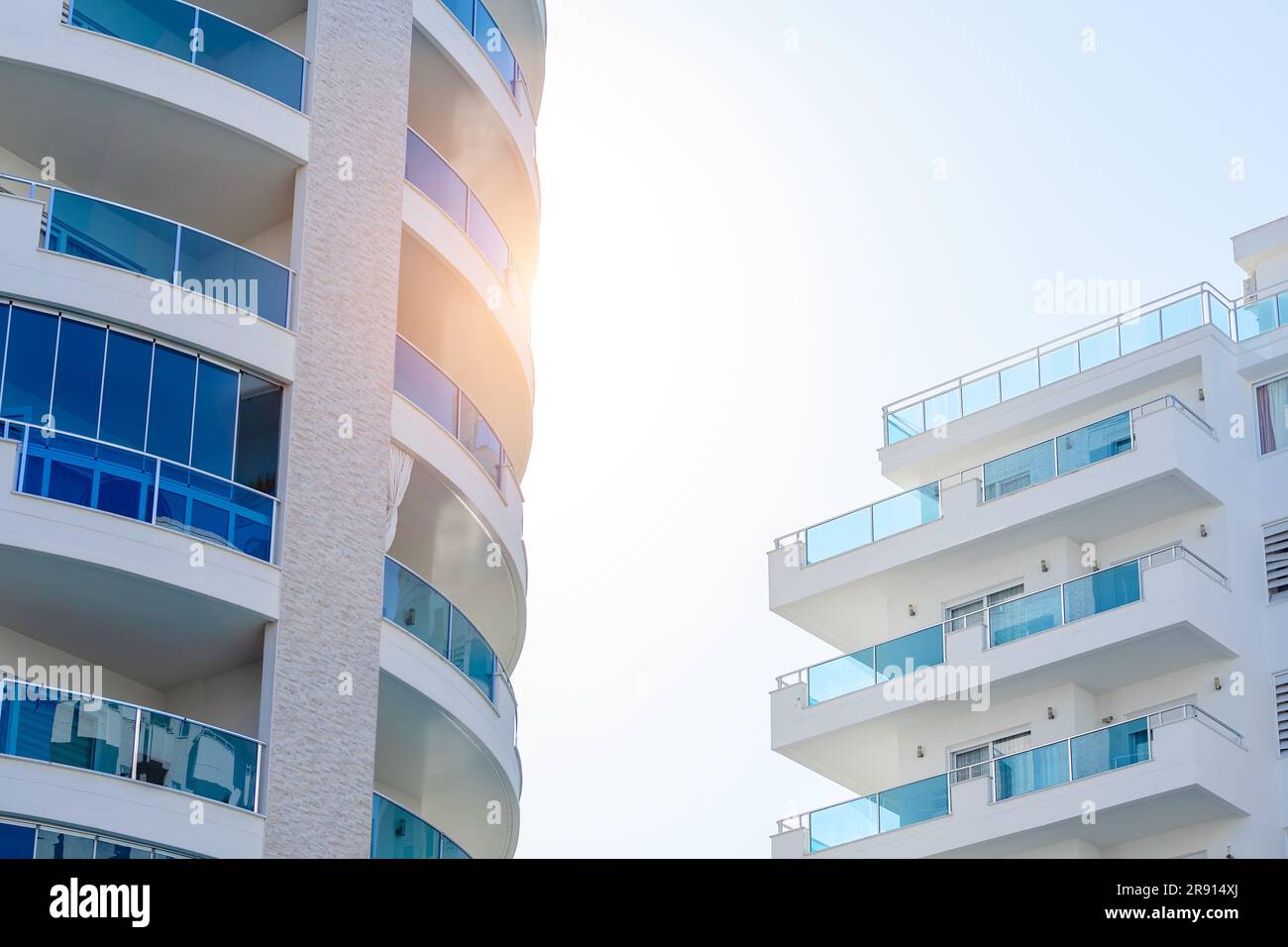 The sun peeking out from behind a tall residential building Stock Photo ...