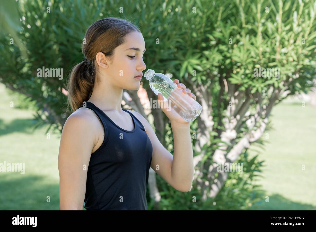 A young girl drinks water from a transparent plastic bottle Stock Photo - Alamy