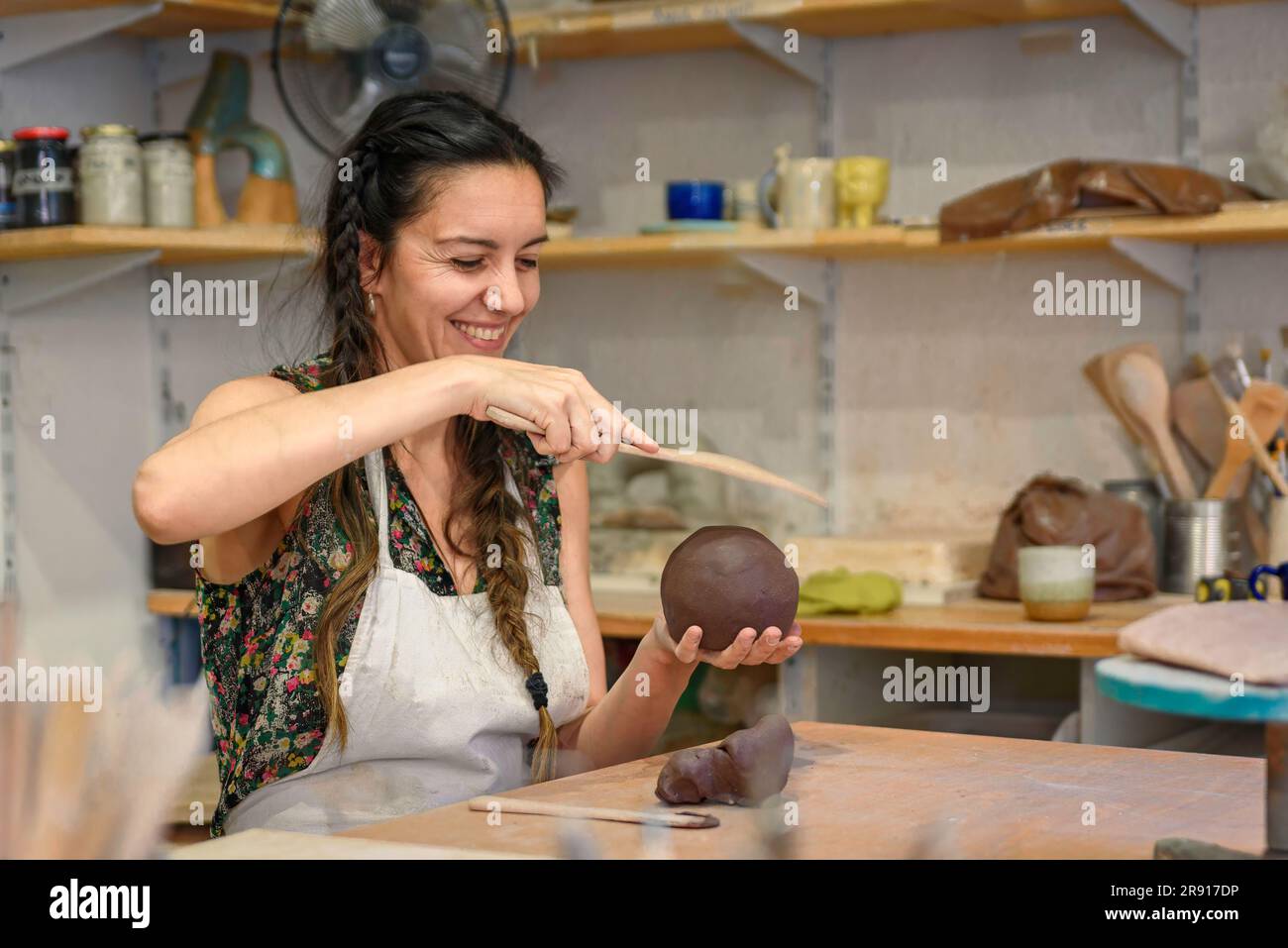 Young woman working raw ceramic and clay to make future ceramic product ...