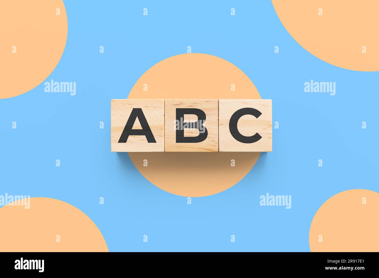 ABC wooden cubes on blue background with yellow circles Stock Photo - Alamy