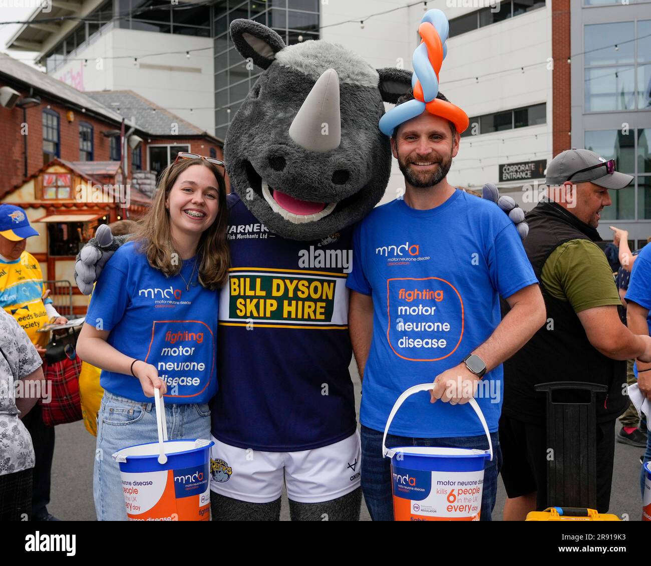 Volunteers with collection buckets for MND pose for a photo with Mascot ...