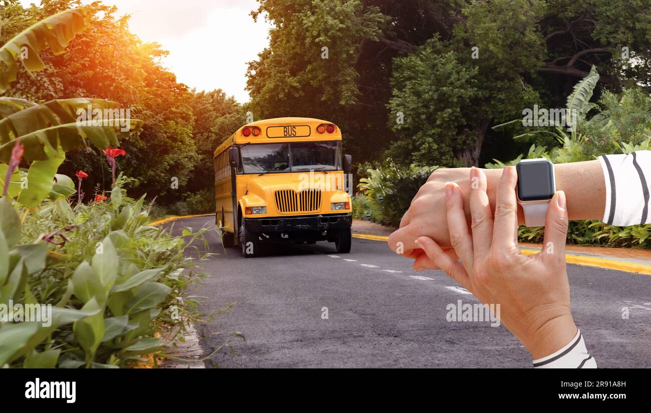 Smart watch on hand on background of yellow bus, checking time of ...