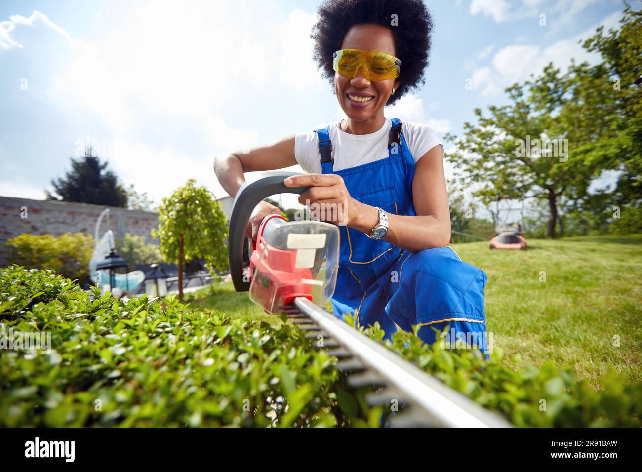 Woman confidently wields a precision trimmer as she skillfully shapes a ...