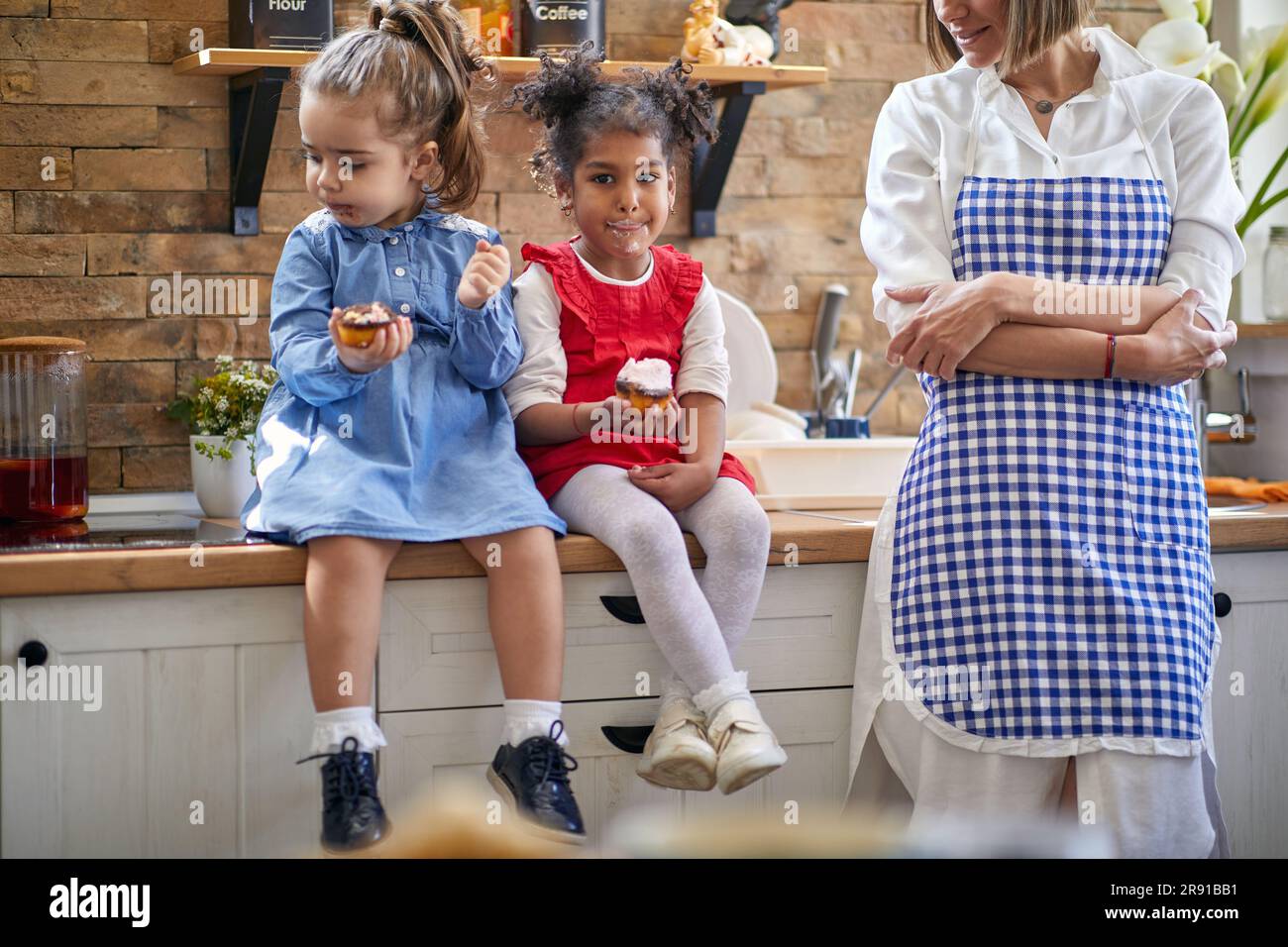 Two young girls are captured in a delightful moment as they sit on the ...