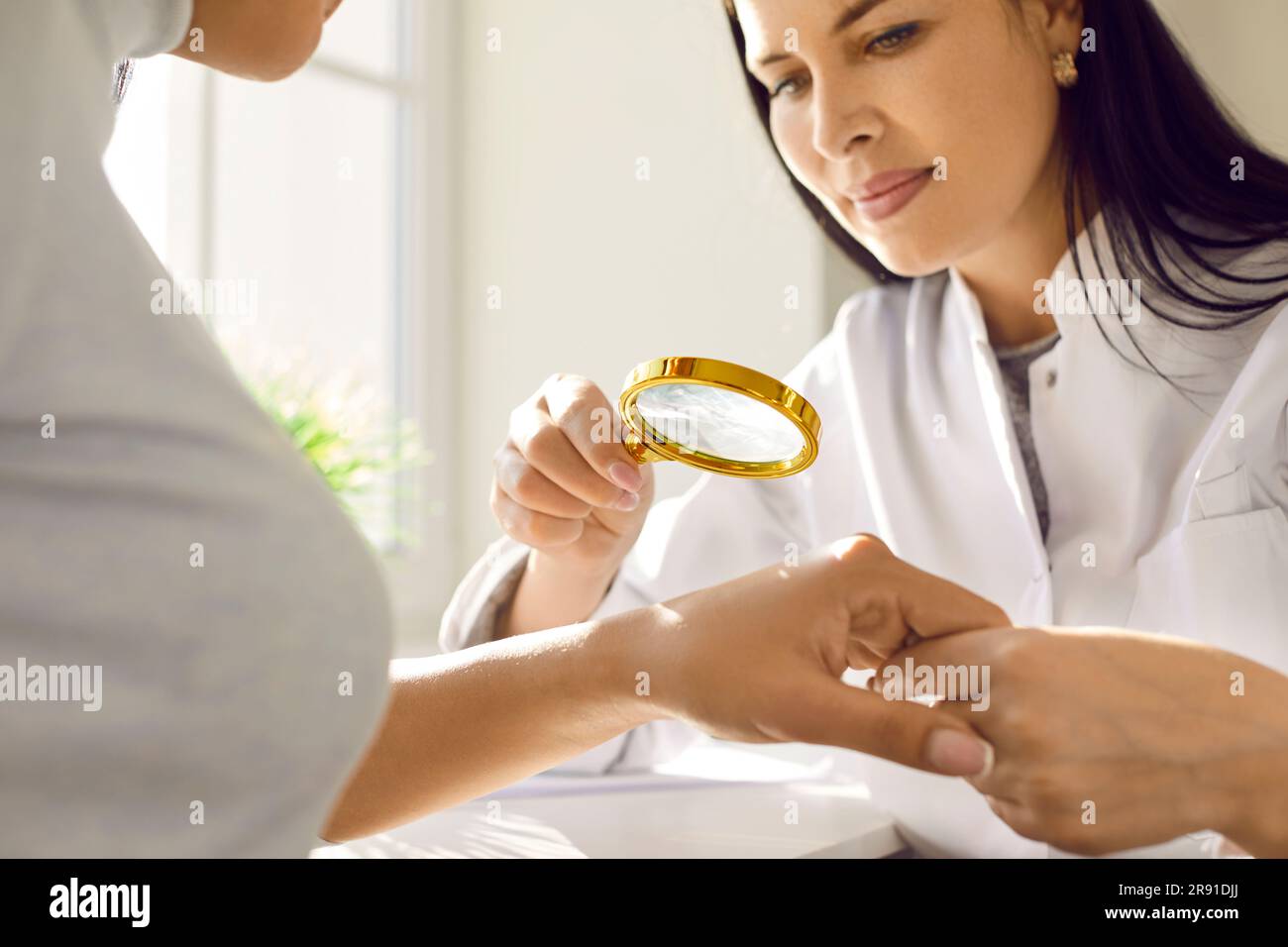 Dermatologist examining young woman's skin and looking through her ...