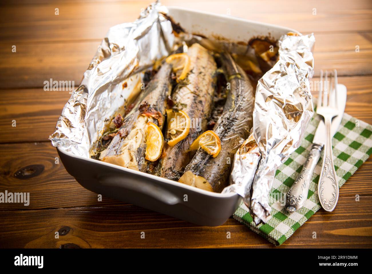 Baked fish with seasonings and spices in foil, in a ceramic form Stock ...