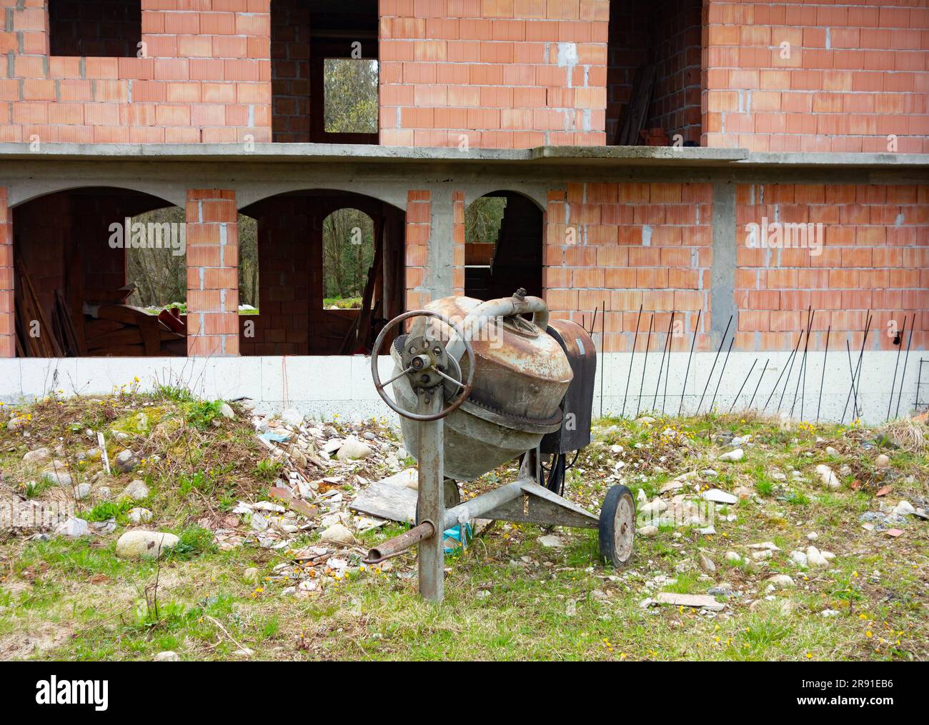 Electric concrete mixer in front of the red brick building built by ...