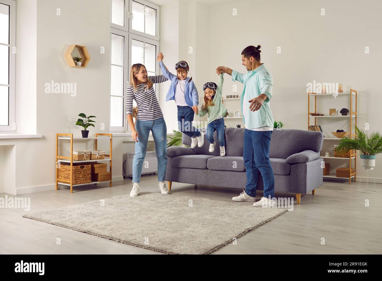 Happy family having fun with their kids in the living room at home ...