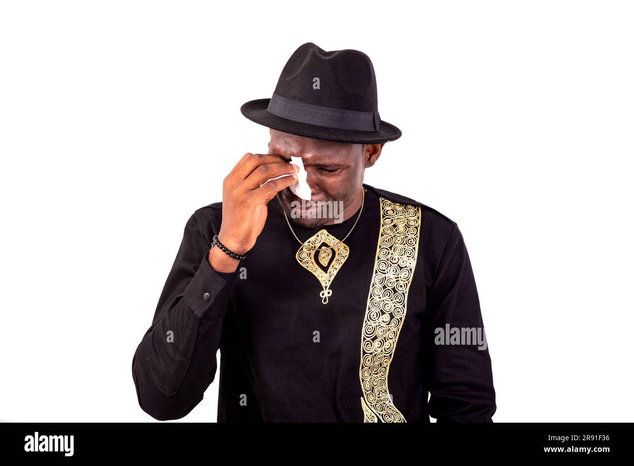 portrait of a well-dressed young man, crying and wiping his tears with ...