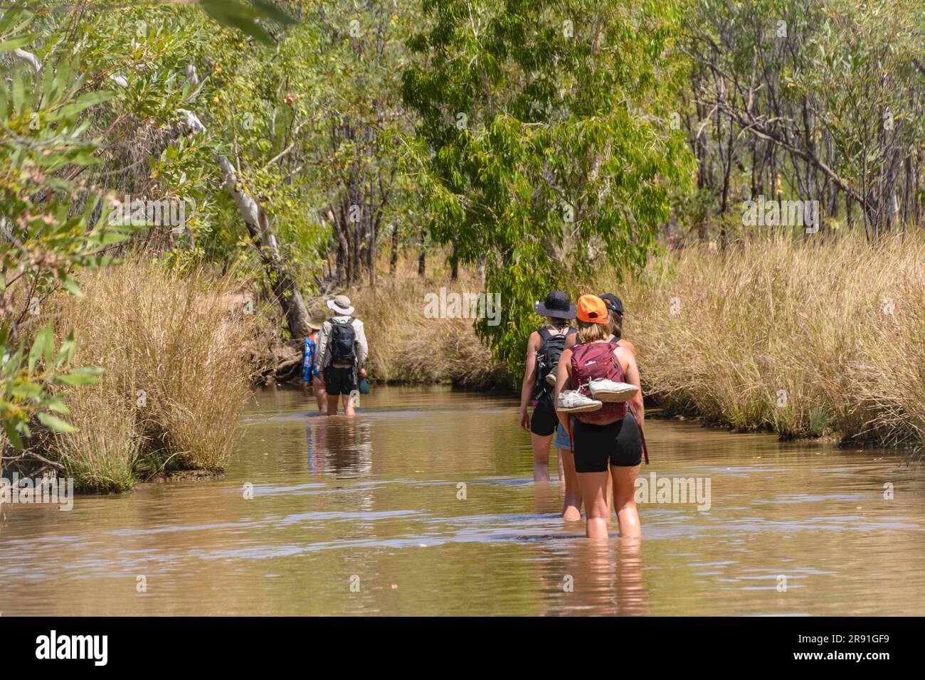 A group of tourists wade through a flooded track to a tourist sight in ...