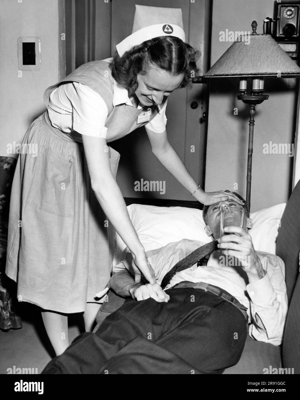 United States: 1937 A Red Cross nurse checks pulse and temperature of ...