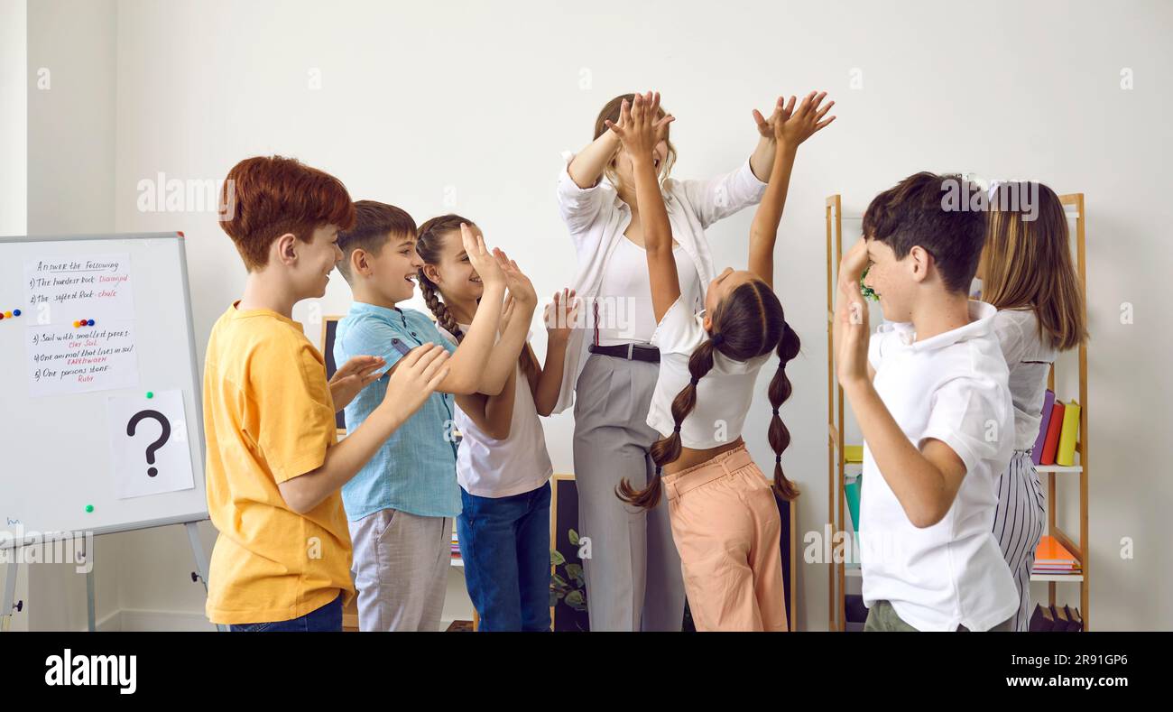 Children playing with their teacher in classroom in elementary school ...