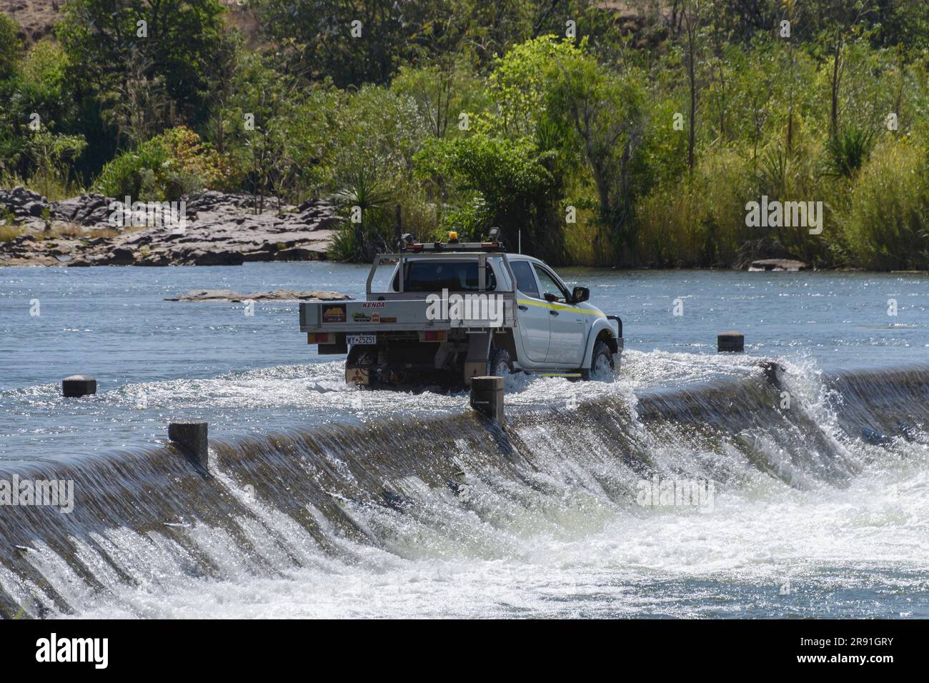 A pick up truck or Ute crossing the flowing waters of the Ord river on ...