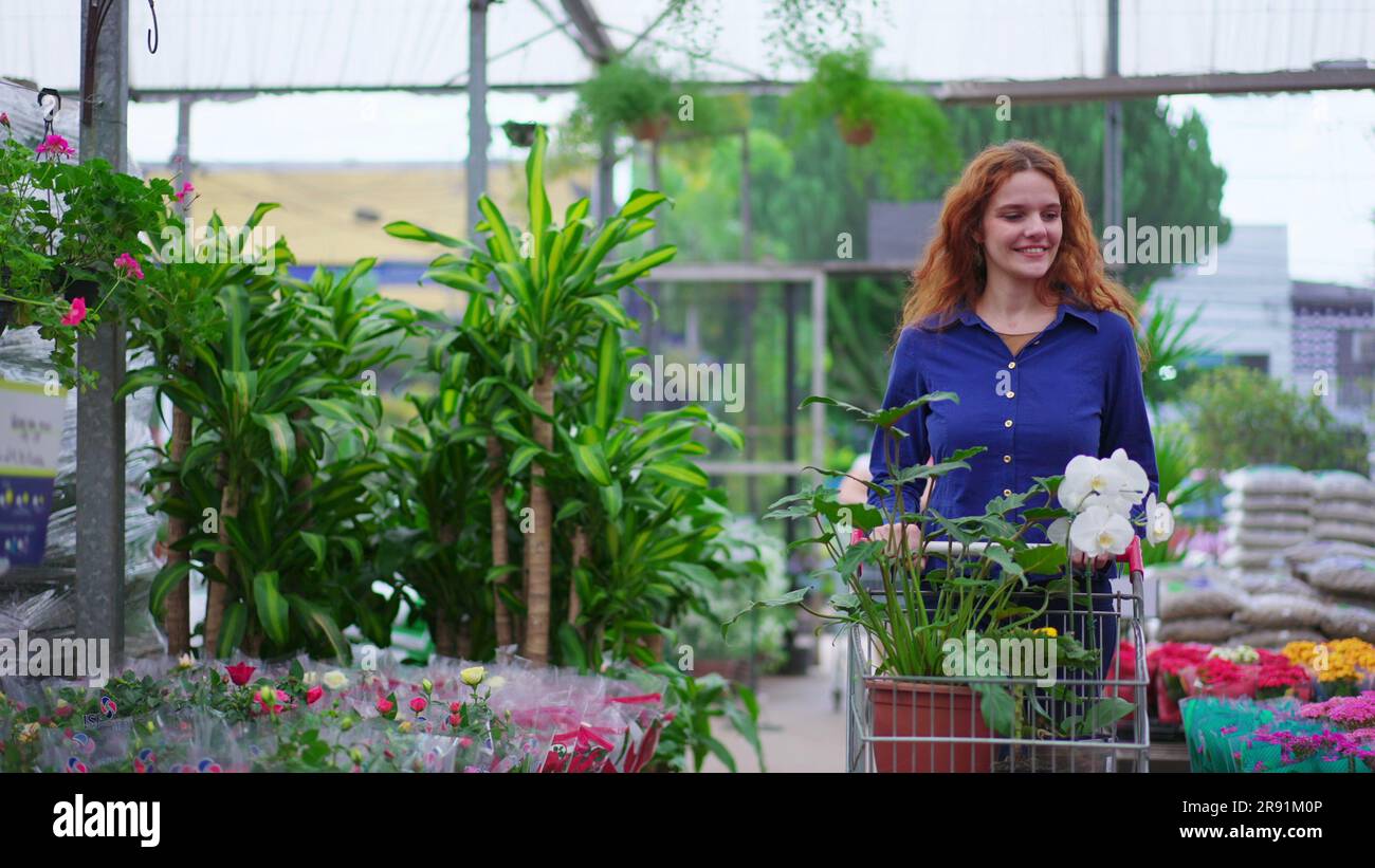 Joyful Woman Selecting Plants and Flowers with Cart in a Flower Shop ...