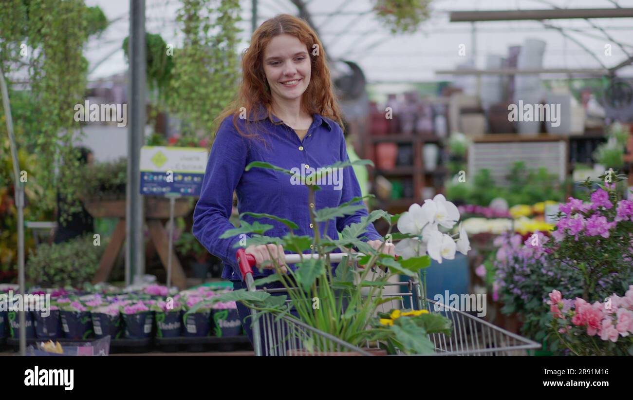 Joyful Woman Selecting Plants and Flowers with Cart in a Flower Shop ...