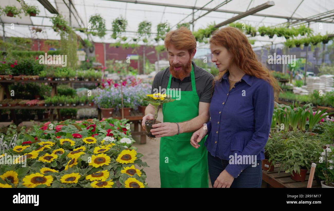 Happy Flower Shop Employee helping customer to guy flower while walking ...