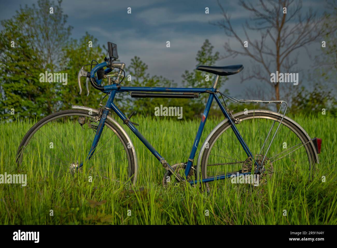 Old bicycle with very modern mobile phone on handlebar on spring color ...