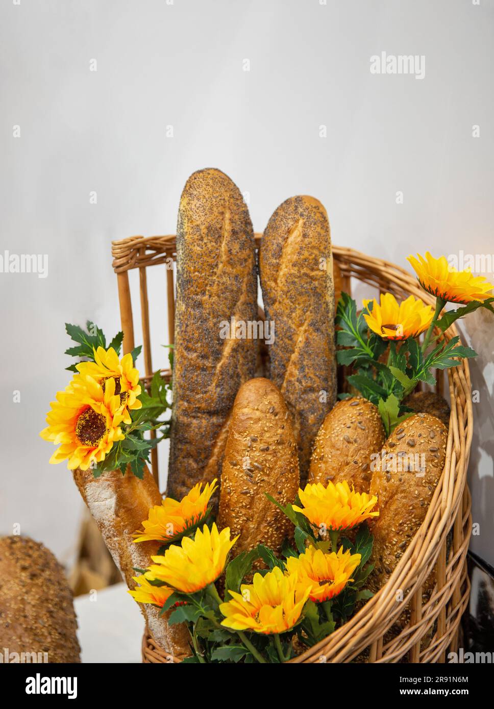 Composition with freshly baked bread and yellow flowers in a wicker ...