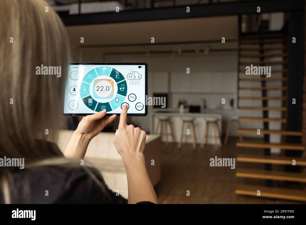 Iot Smart Home Concept - rear view of woman ask digital tablet to set temperature of air ...