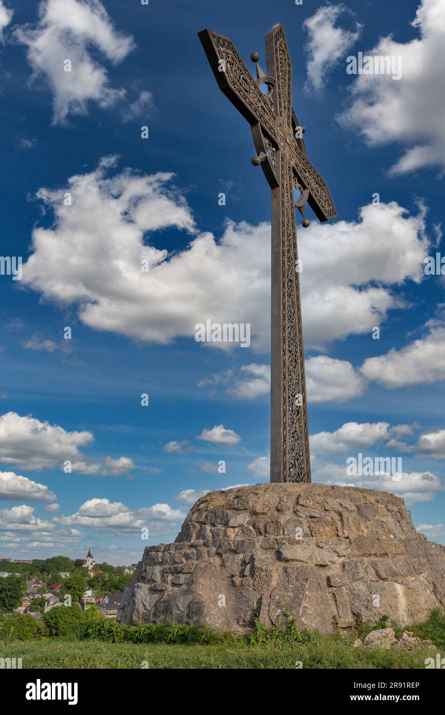 Metal religious cross in front of castle in Kamianets-Podilskyi ...
