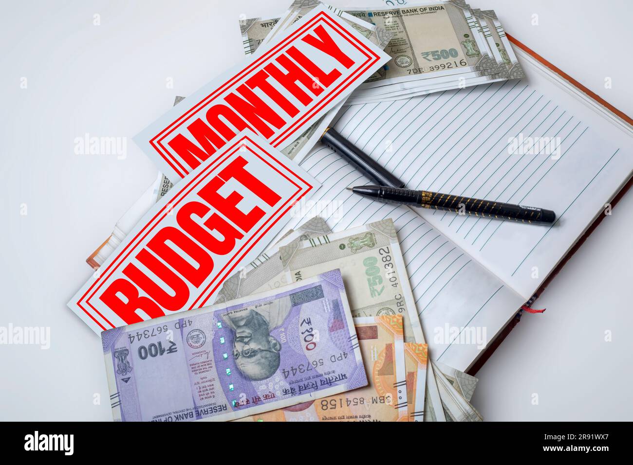 Monthly budget planning: Indian currency notes with pen on a open ...