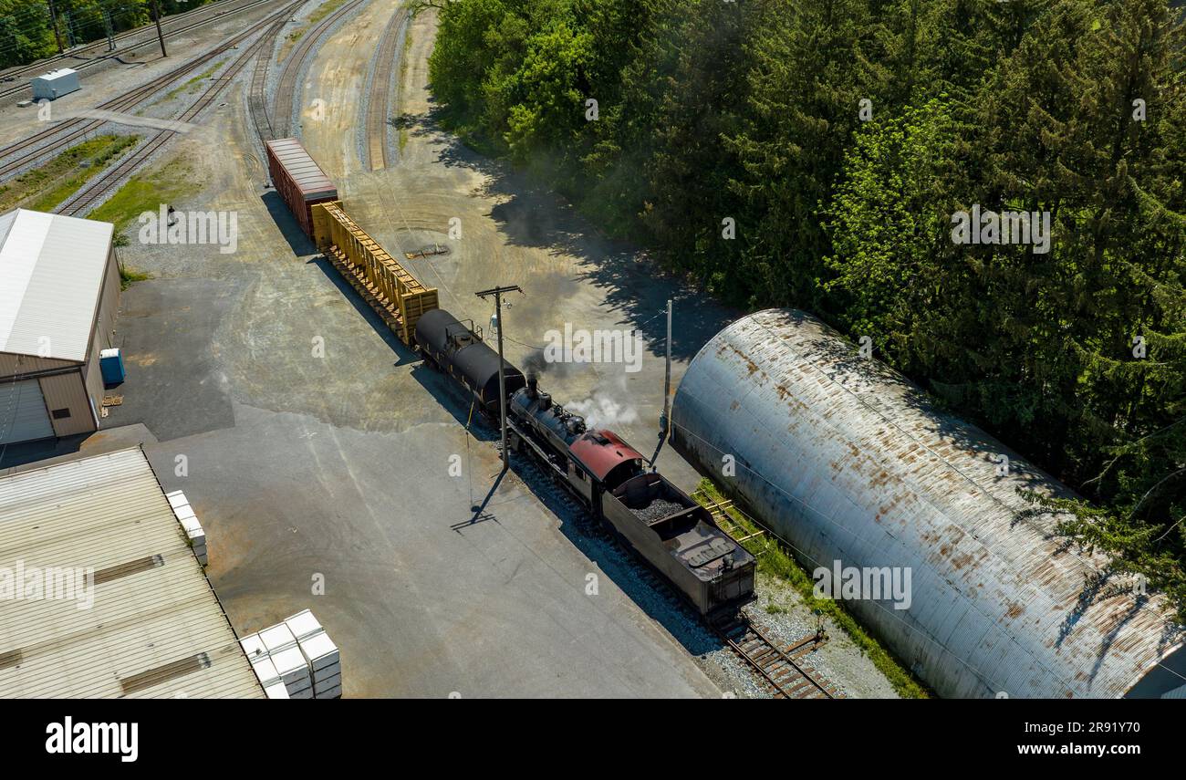 An Aerial View of a Steam Locomotive Moving Freight Cars Around in a ...