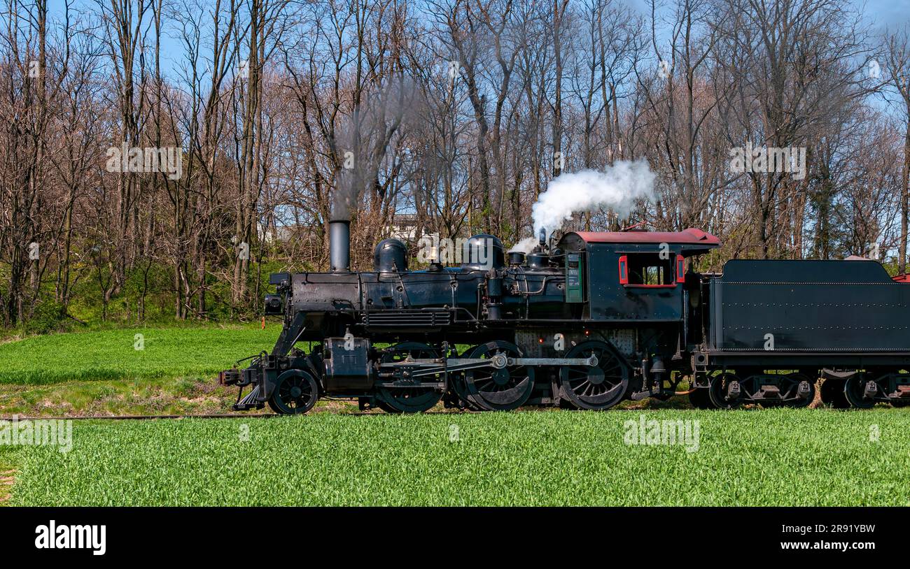 A Side View of a Restored Steam Locomotive Standing Still Blowing Smoke ...