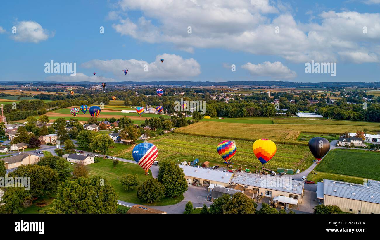 A Drone View of Multiple Colorful Hot Air Balloons Landing in Farms ...
