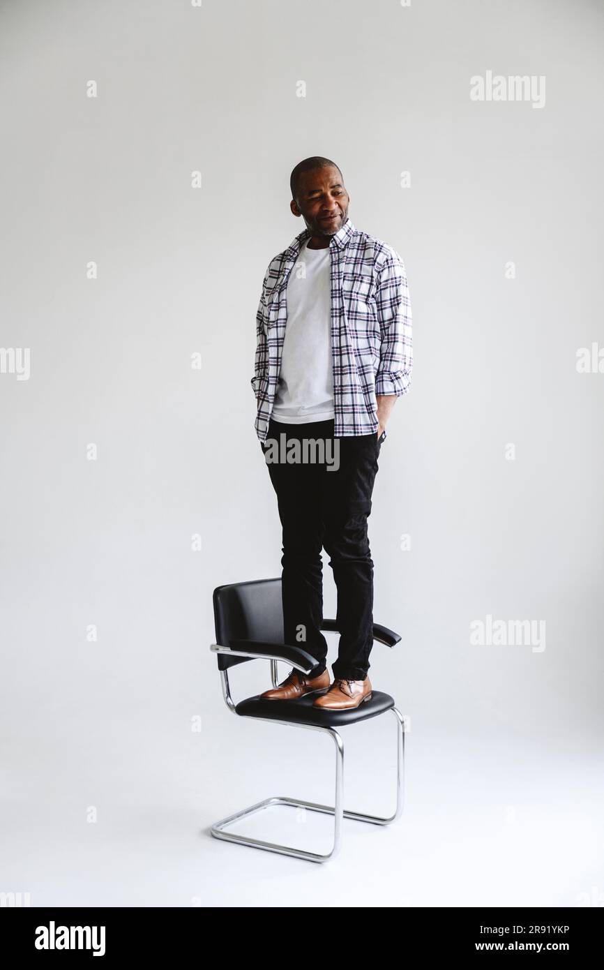 Man standing on chair hi-res stock photography and images - Alamy