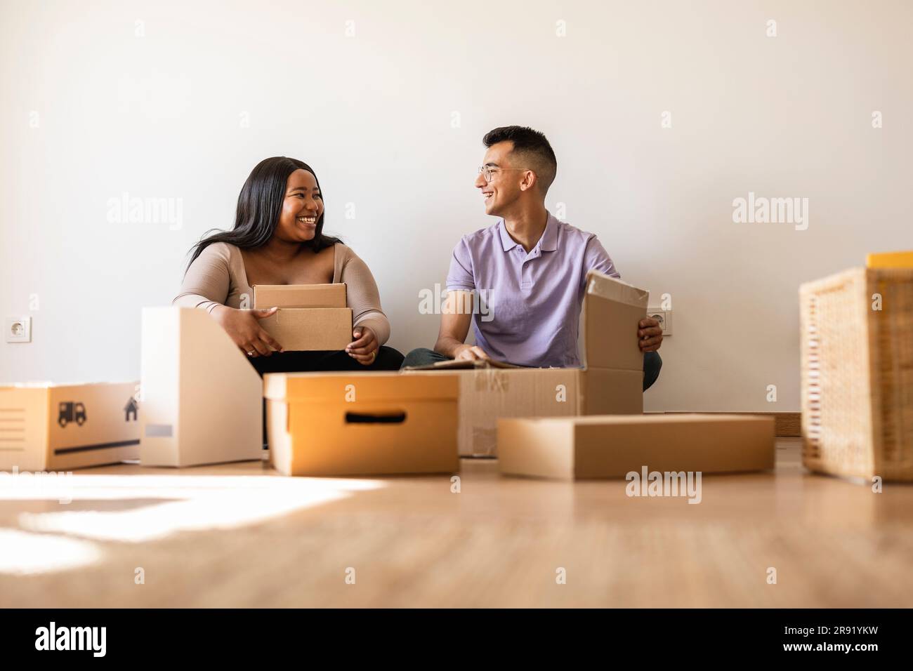 Happy couple unpacking cardboard boxes in new home Stock Photo - Alamy