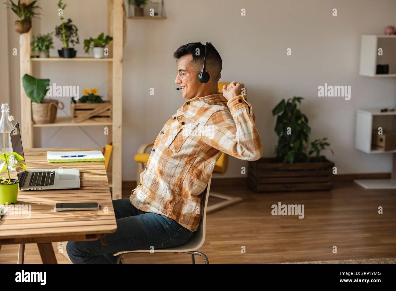 Freelancer stretching sitting on chair at home office Stock Photo - Alamy
