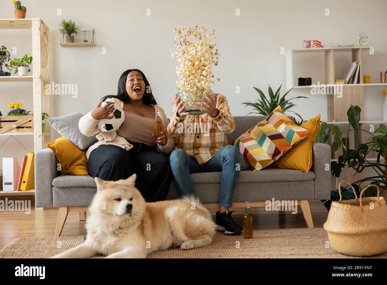 Excited couple tossing popcorn and watching TV at home Stock Photo - Alamy