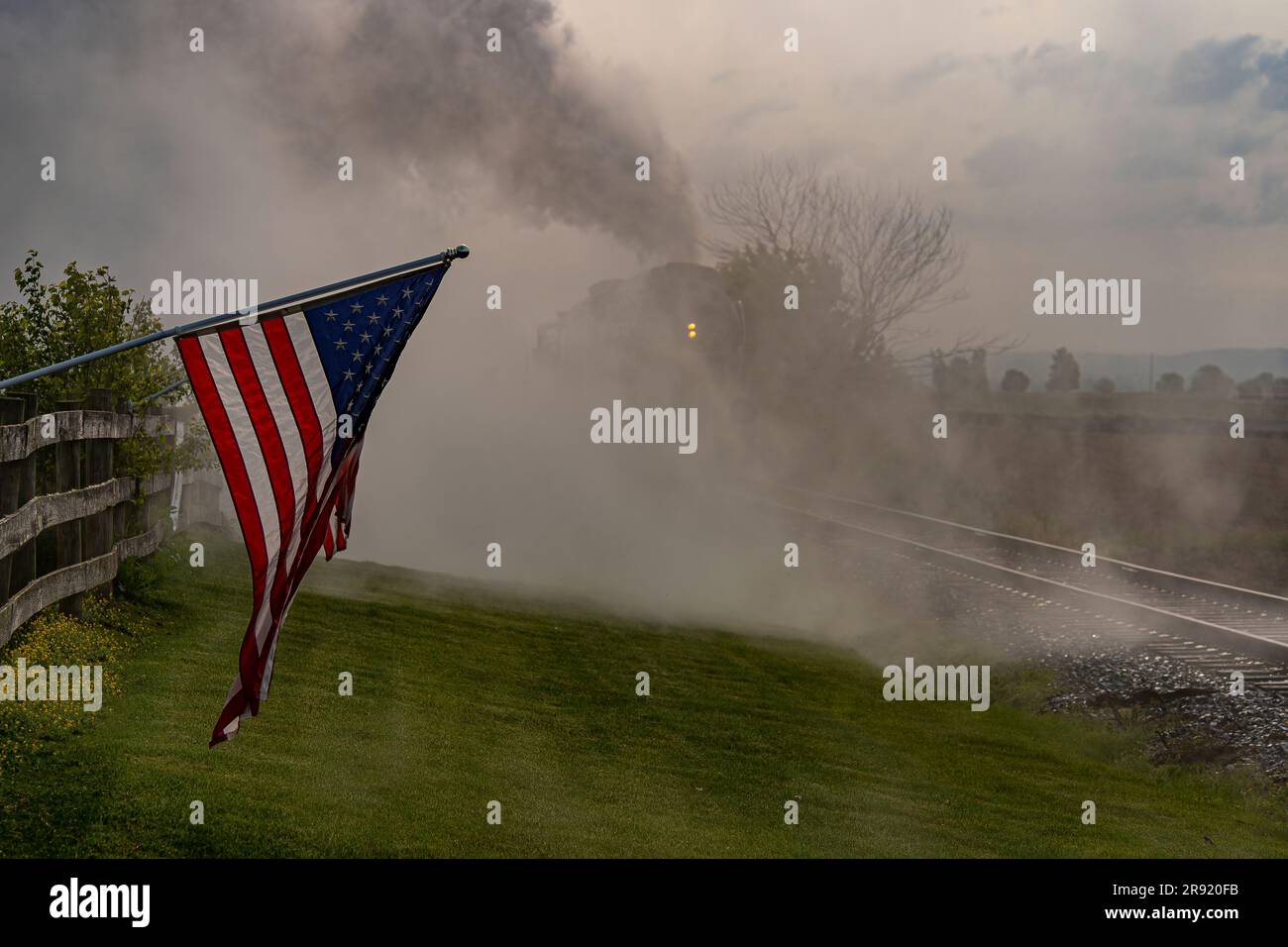 A Steam Locomotive Backing Up Blowing Lots of Smoke With a America Flag ...