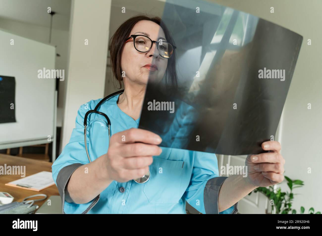 Concentrated doctor examining X-ray at medical practice Stock Photo - Alamy
