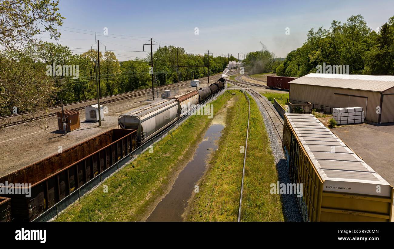 An Aerial View of a Steam Locomotive Moving Freight Cars Around in a ...