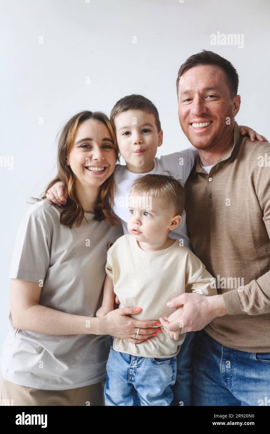 Happy father and mother with sons against white background Stock Photo ...